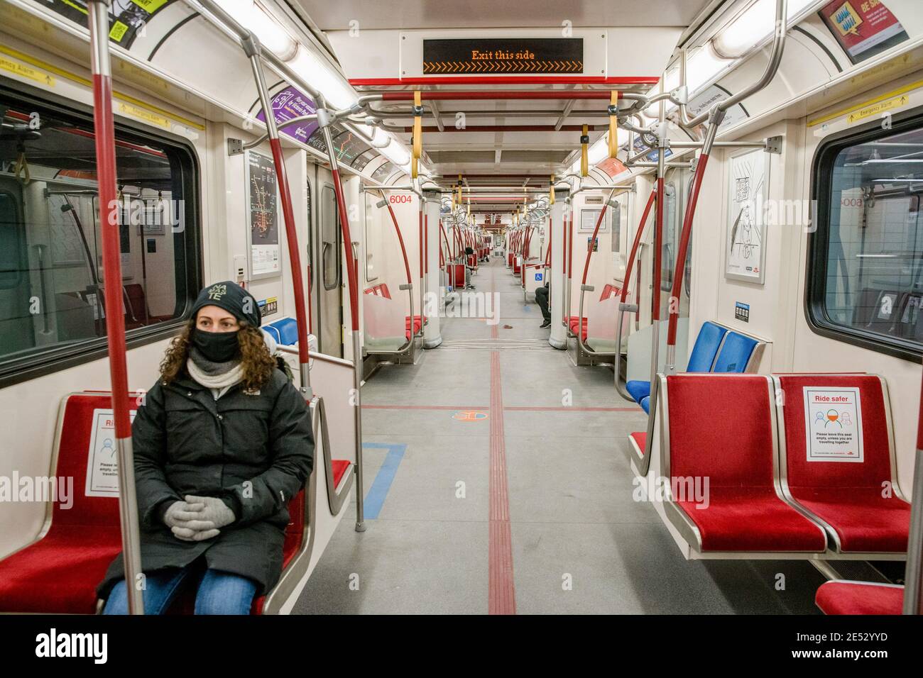 Woman wearing a face mask sits on an empty subway. Toronto is now under ...