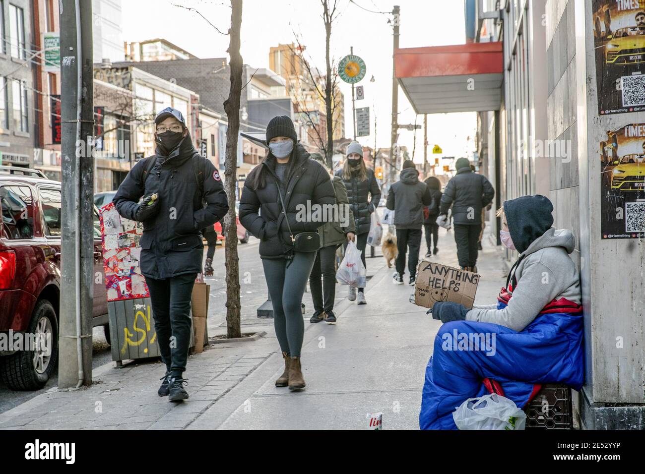 People wearing face masks walk along Queen street. Toronto is now under ...