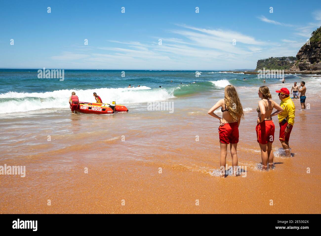 Volunteer surf rescue lifesavers launch inflatable red zodiac surf ...