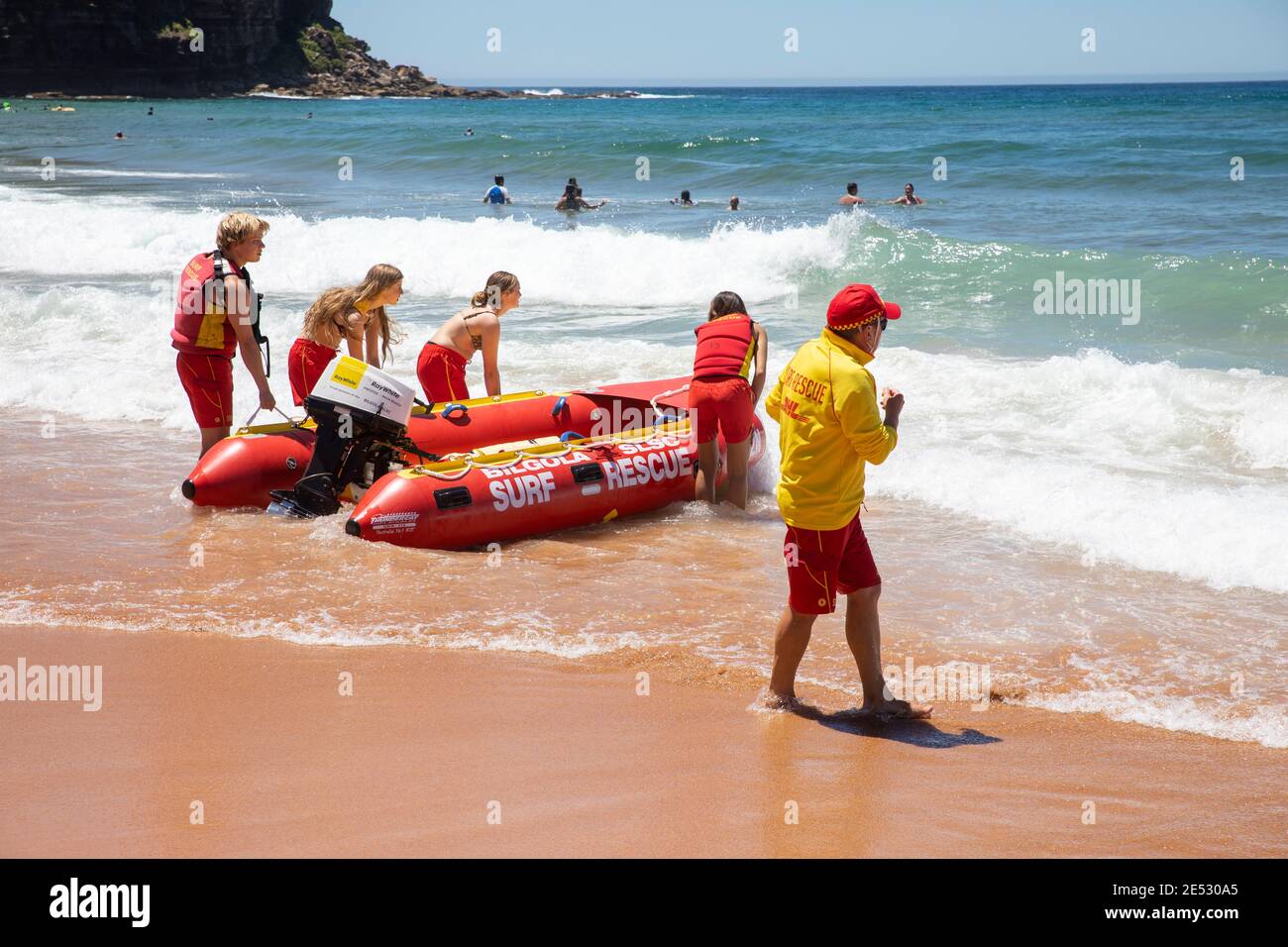 Volunteer surf rescue lifesavers launch inflatable red zodiac surf ...