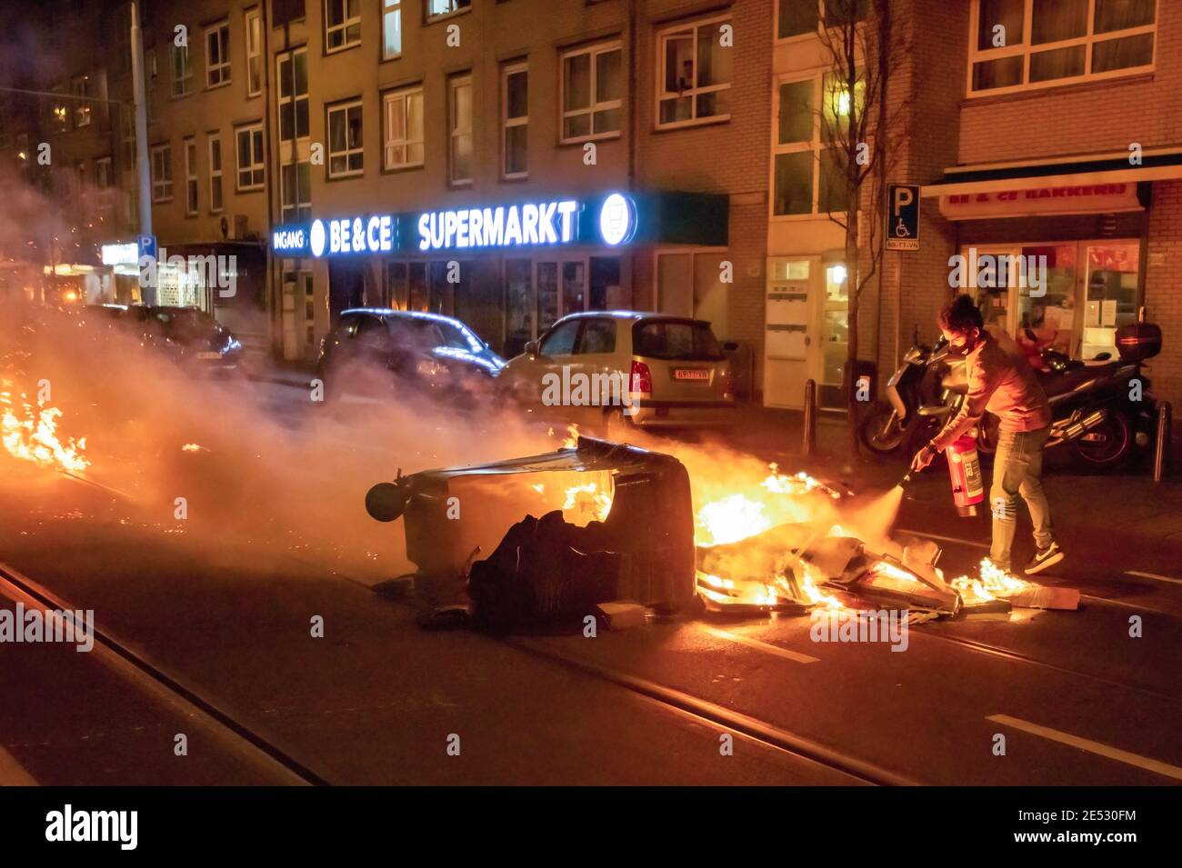 Local resident attempts to extinguish fire started by the rioters.Riot ...