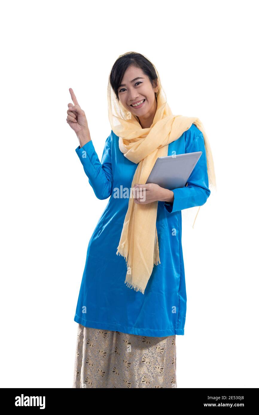 portrait of muslim woman thinking and looking up pointing to copyspace ...