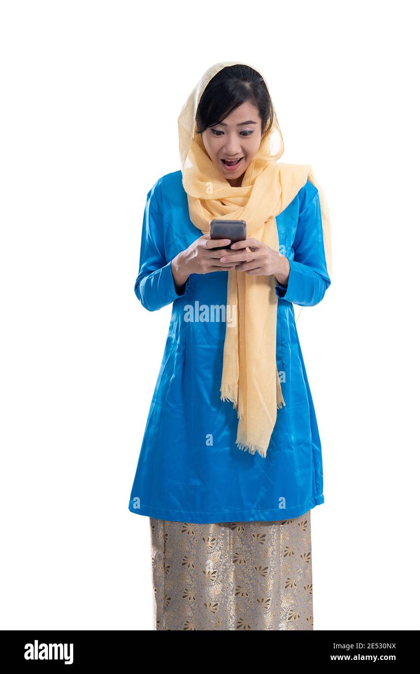excited muslim woman looking at her phone isolated over white ...