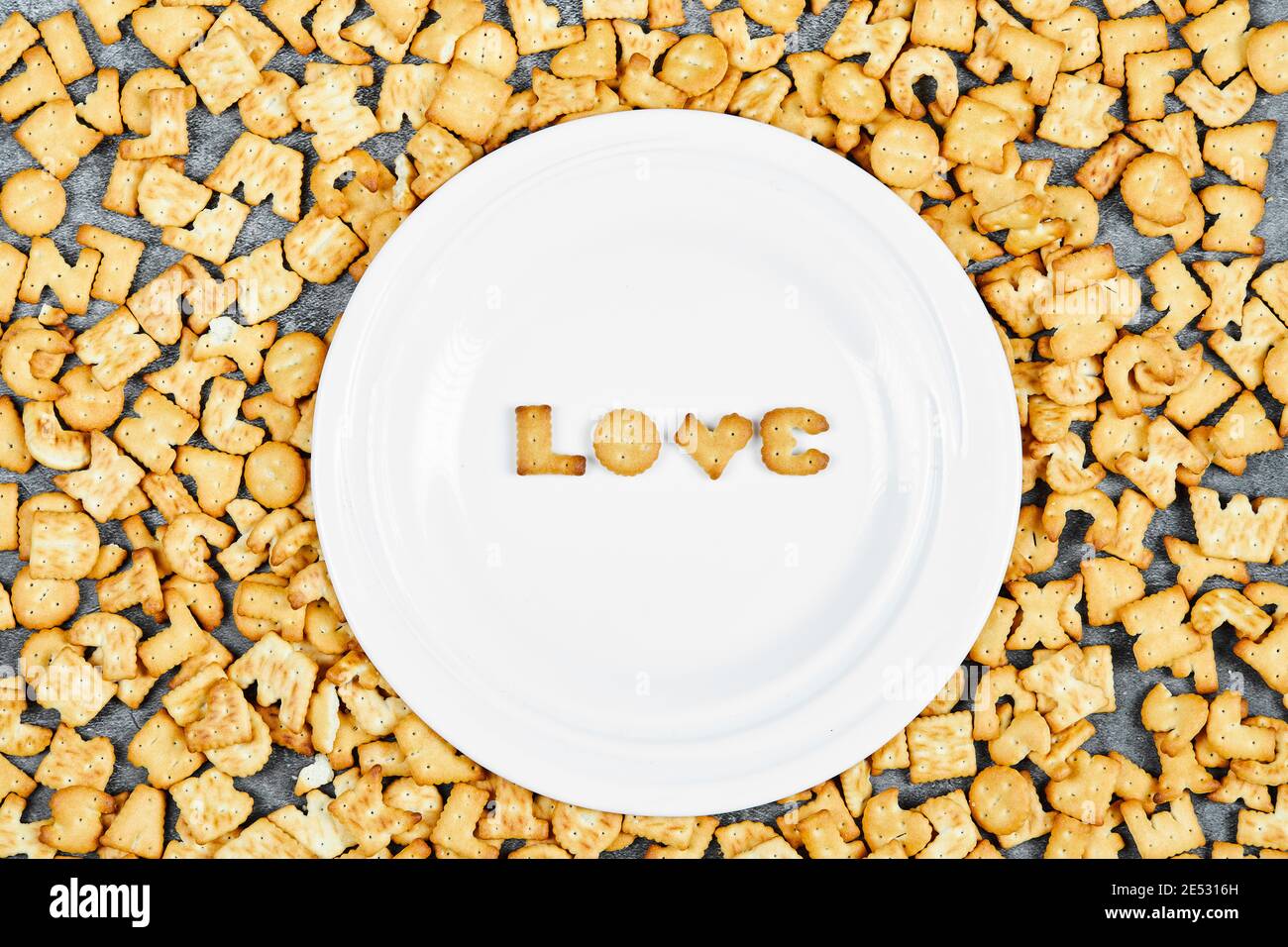 Scattered alphabet crackers and word love spelled with crackers on a ...