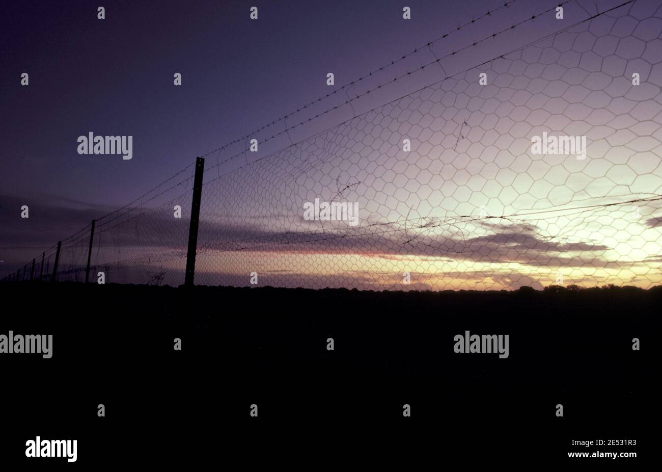 SILHOUETTE OF PART OF A SECTION OF THE DINGO FENCE, OUTBACK AUSTRALIA ...