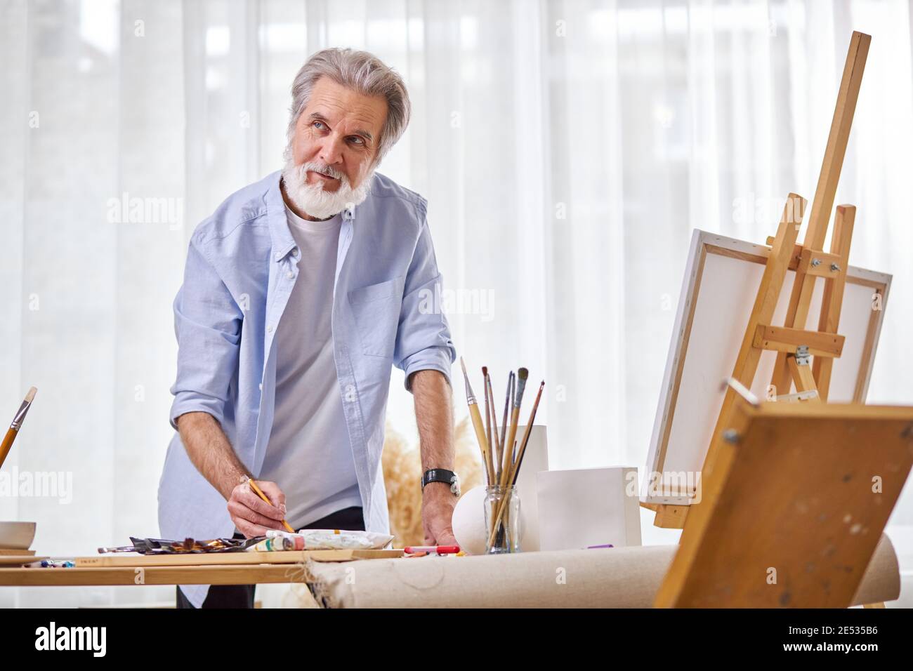 artist during work, stand in contemplation, thinking while drawing ...