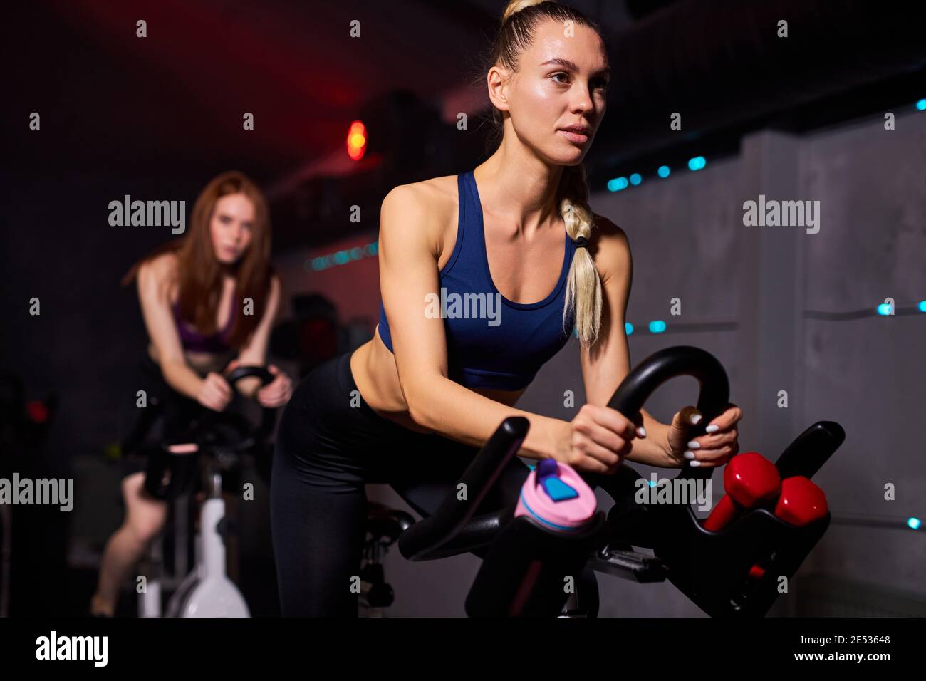 fit woman at the gym exercising on a stationary bike in gym. cardio ...