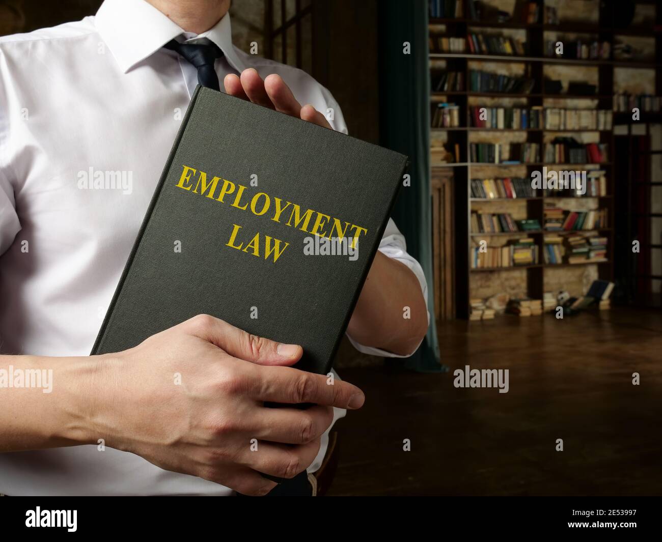 Worker holds employment law in the library Stock Photo - Alamy