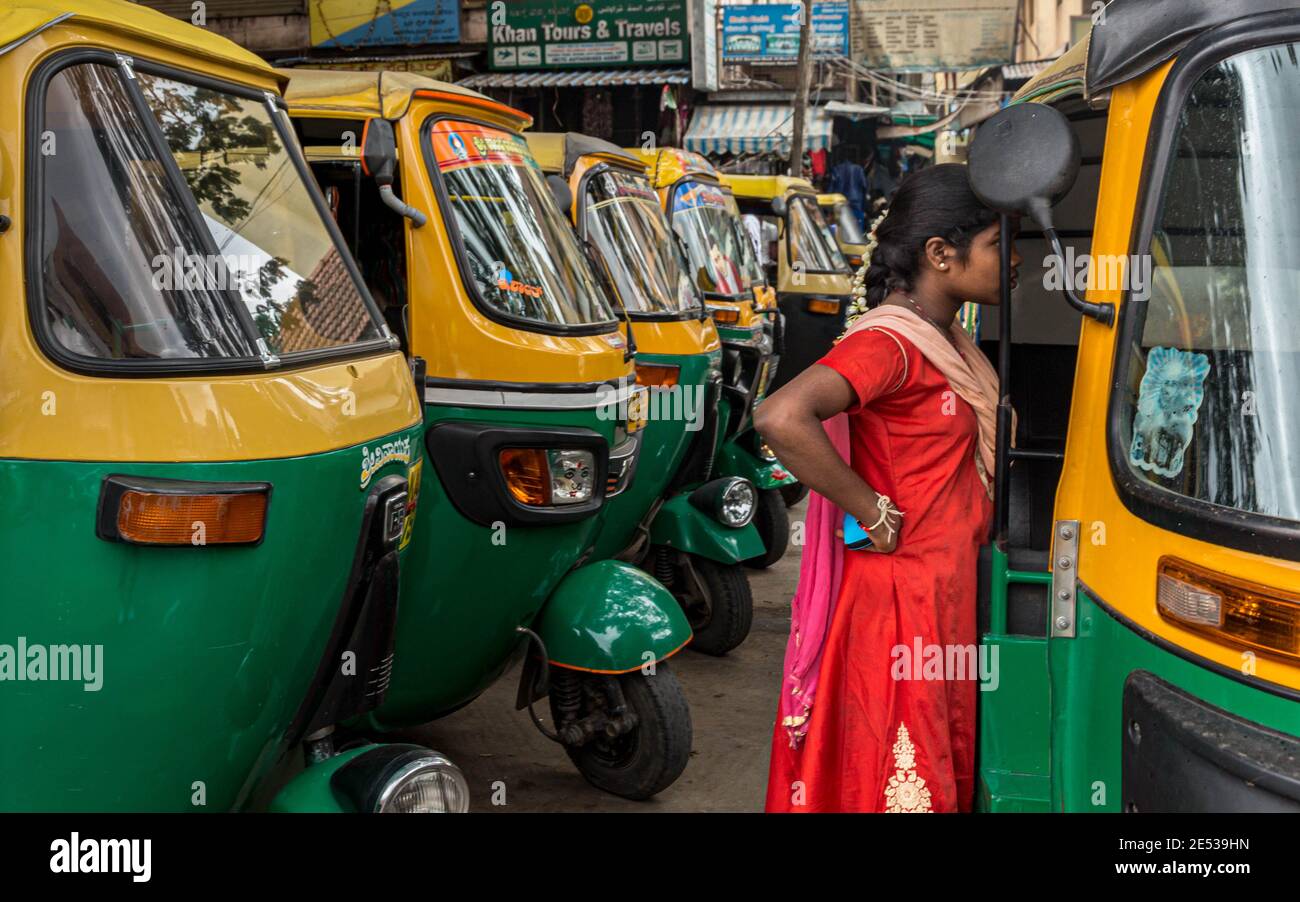 A young Indian girl in traditional red saree peeking into the window of ...
