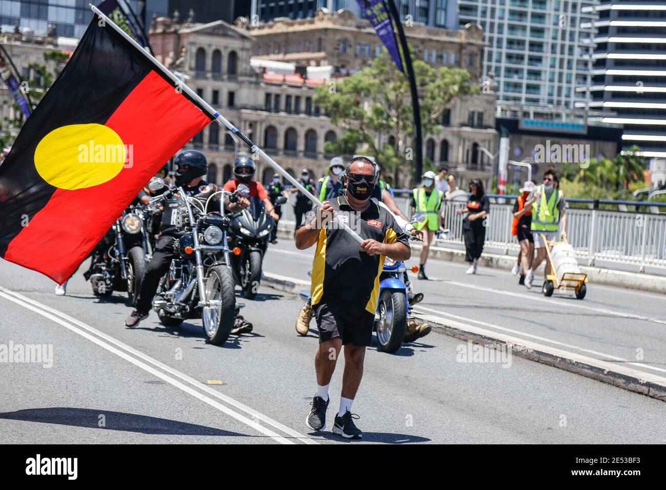 A protester waves the Aboriginal Flag across Victoria Bridge during the ...