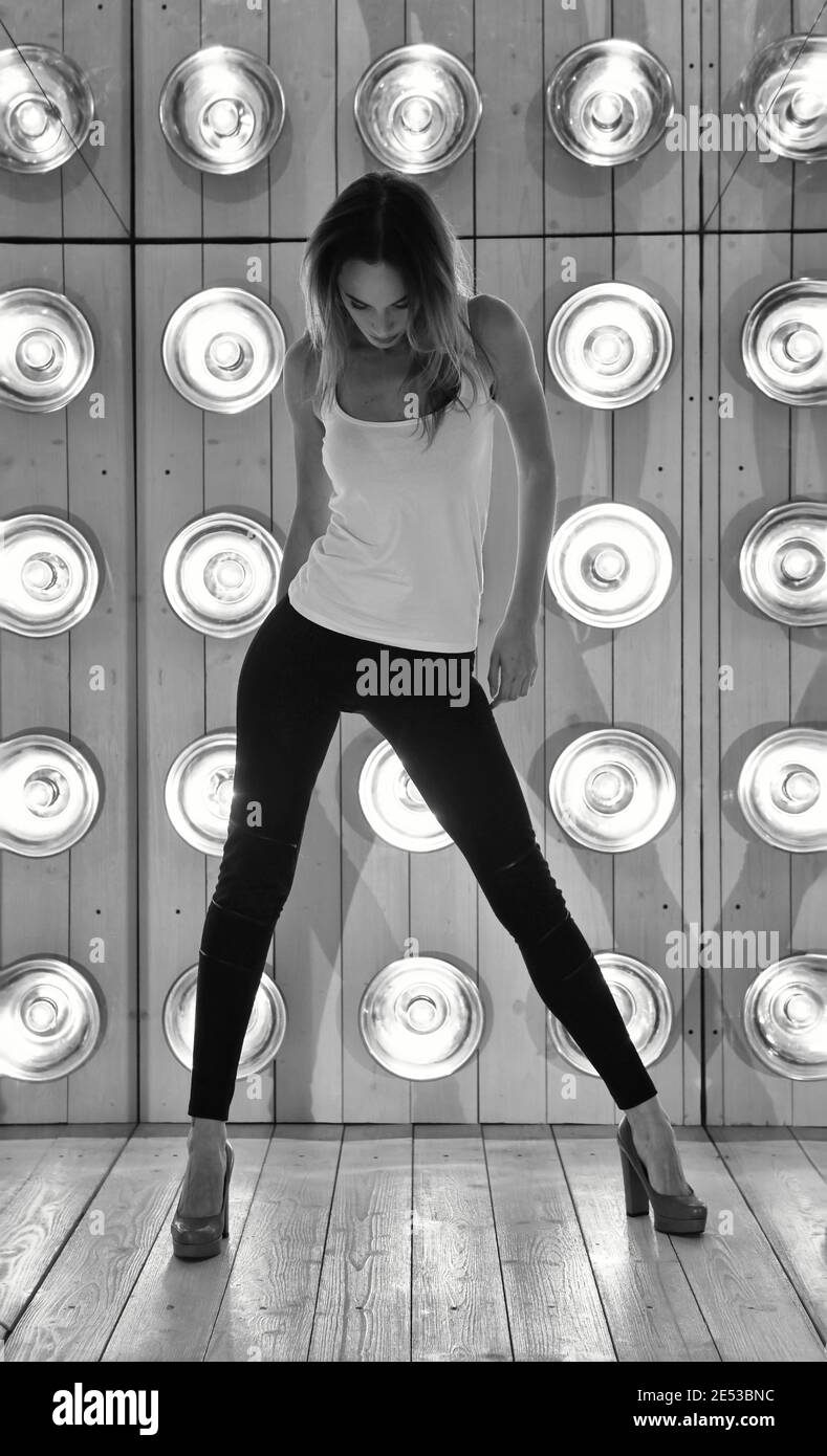 high heel woman poses against stage lights with surreal reflections ...