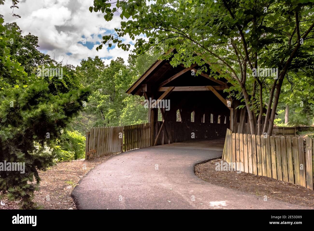 Paved pathway leading to a covered bridge Stock Photo - Alamy