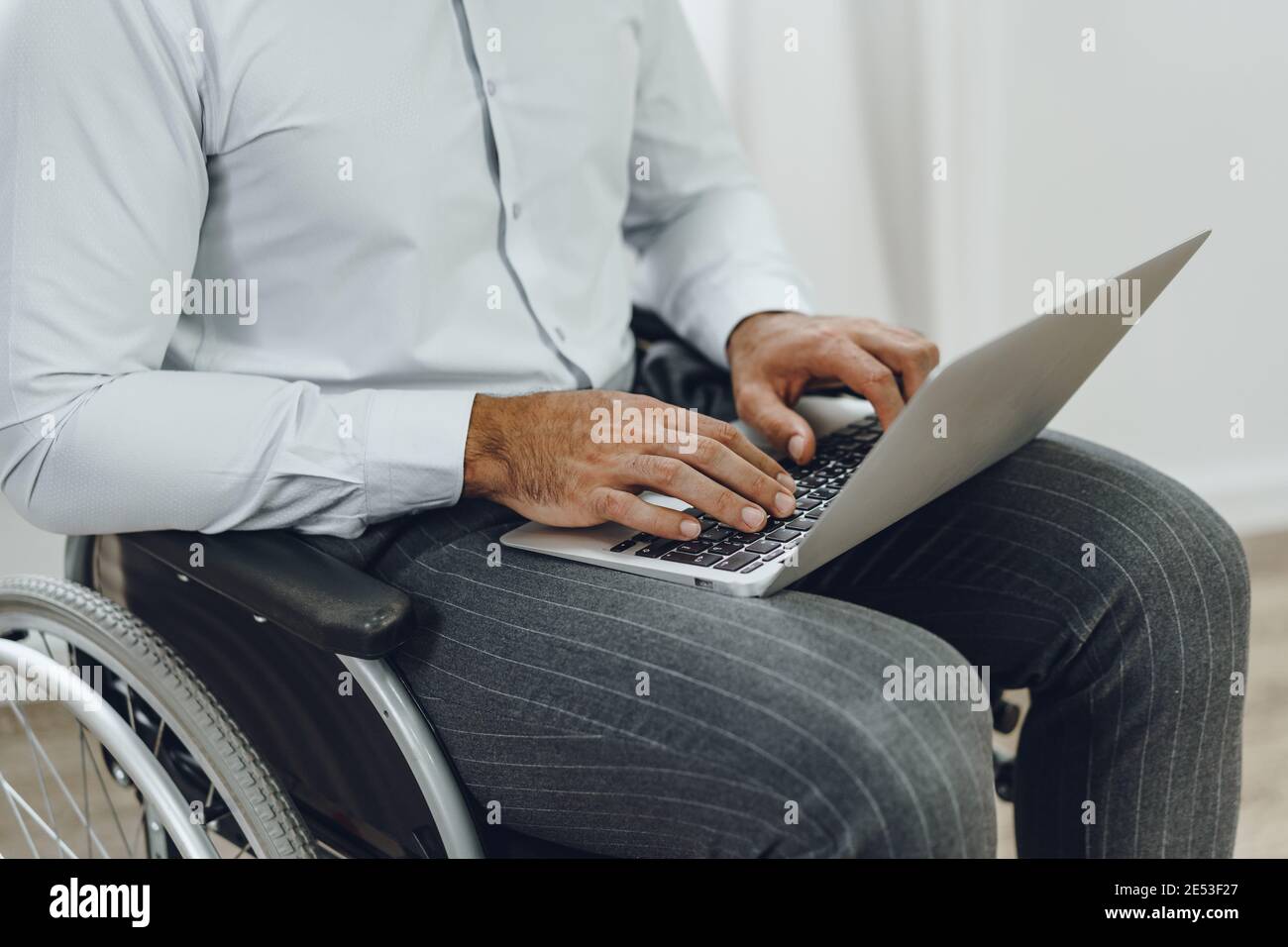 Disabled man in a wheelchair using laptop Stock Photo - Alamy