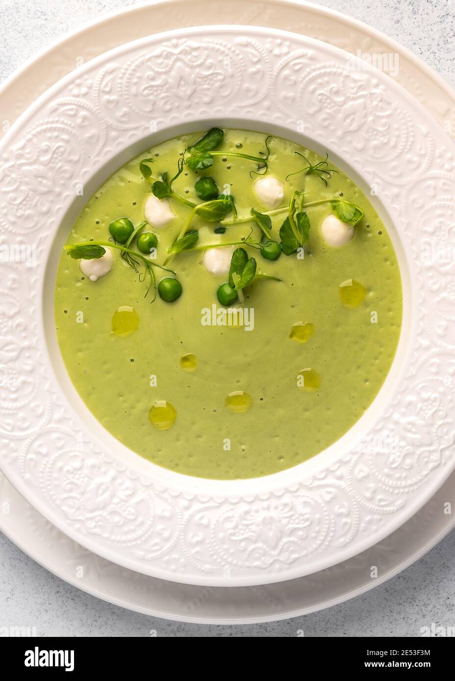 Vertical view homemade soup puree of green peas, coconut milk with mini ...