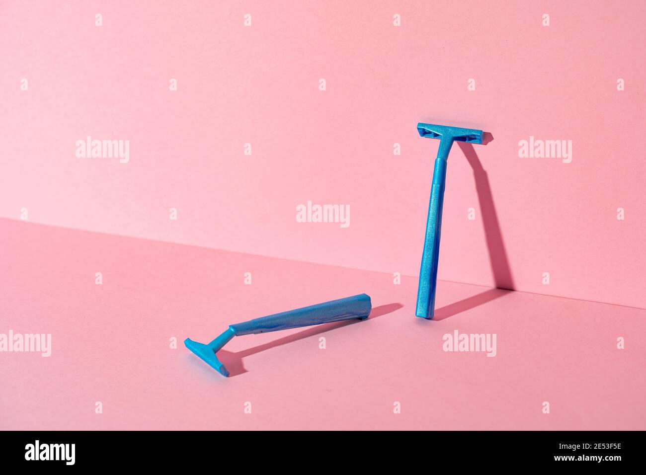 Blue disposable razors on pink paper background Stock Photo - Alamy
