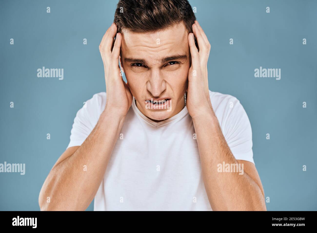 emotional displeased man cropped view white t-shirt blue background ...