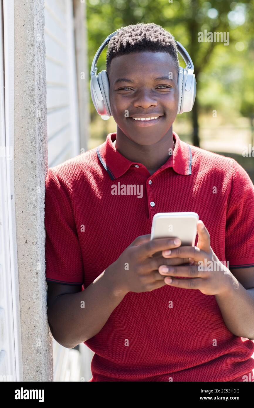 Black teen boy looking at phone hi-res stock photography and images - Alamy