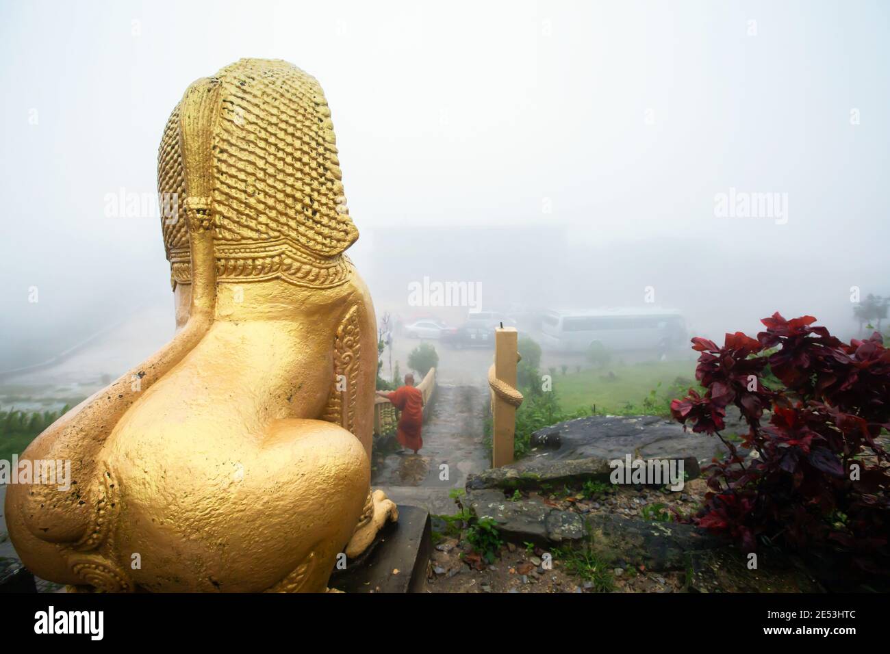 A Khmer monk walking on the stairs in front of the giant Singha Khmer ...