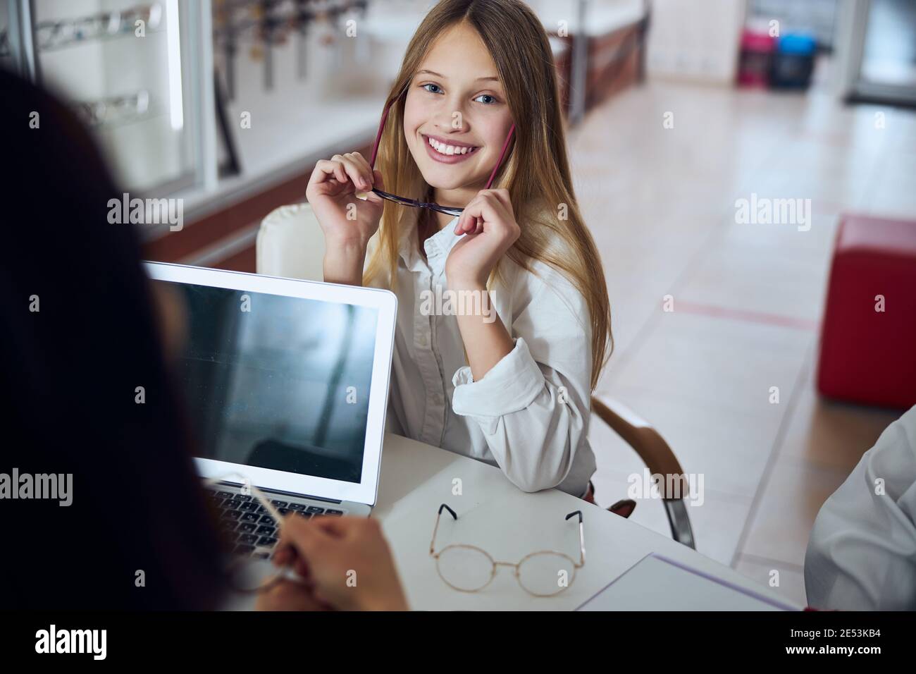 Pretty young lady in casual clothes looking at the camera while holding ...