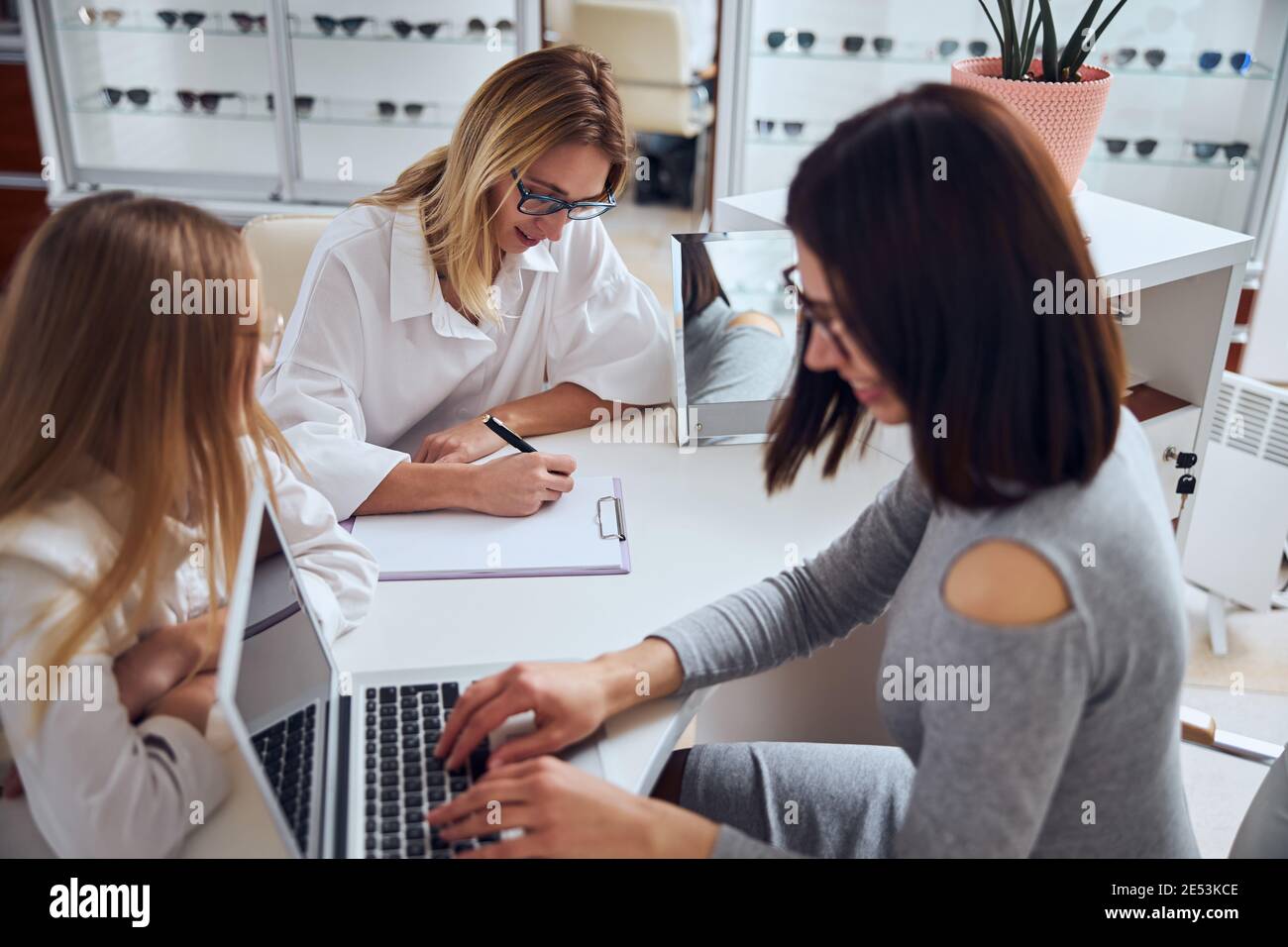 Beautiful elegant patient of ophthalmology clinic having dialog with ...