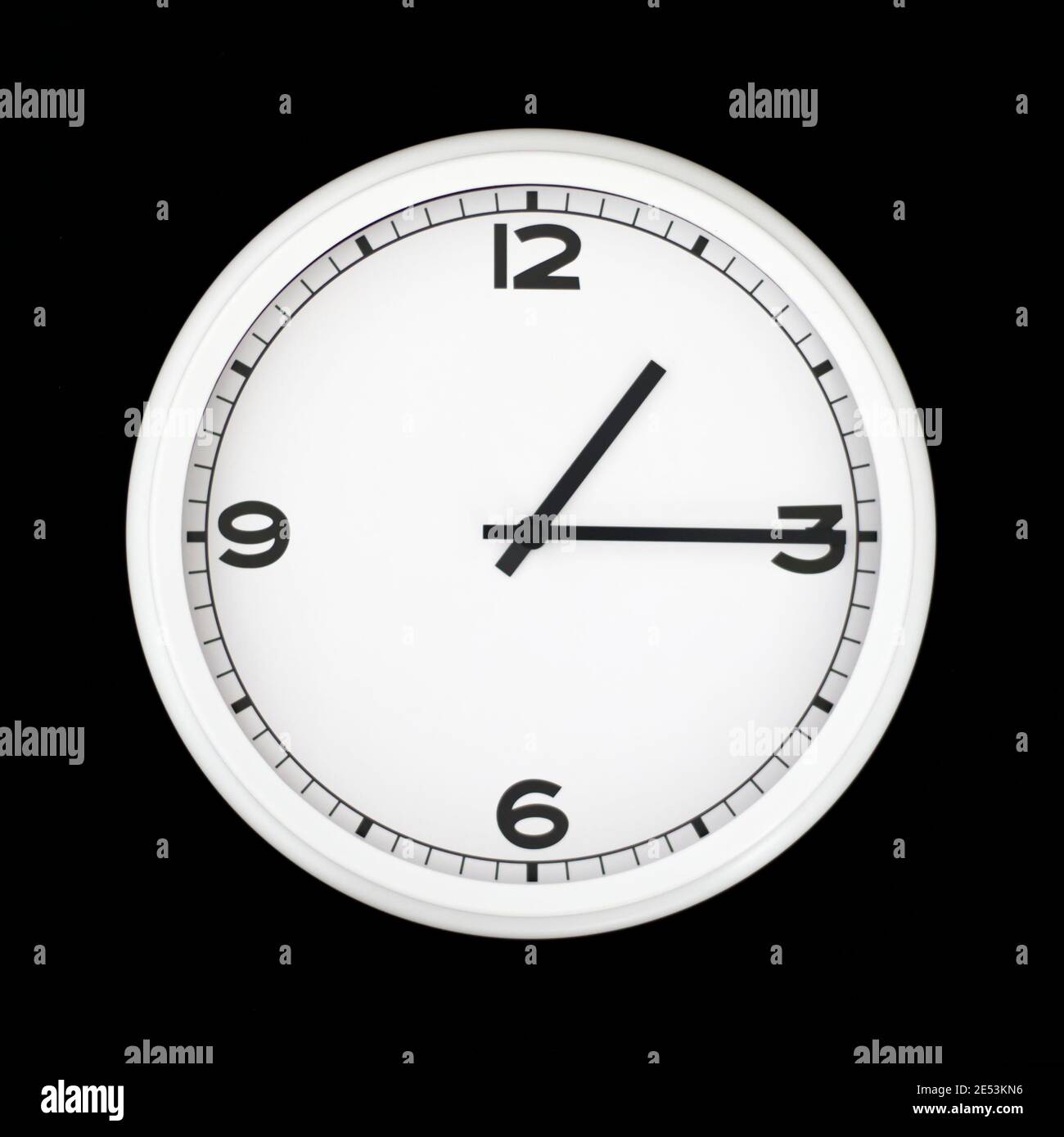 White round analog wall clock isolated on black background, its quarter ...