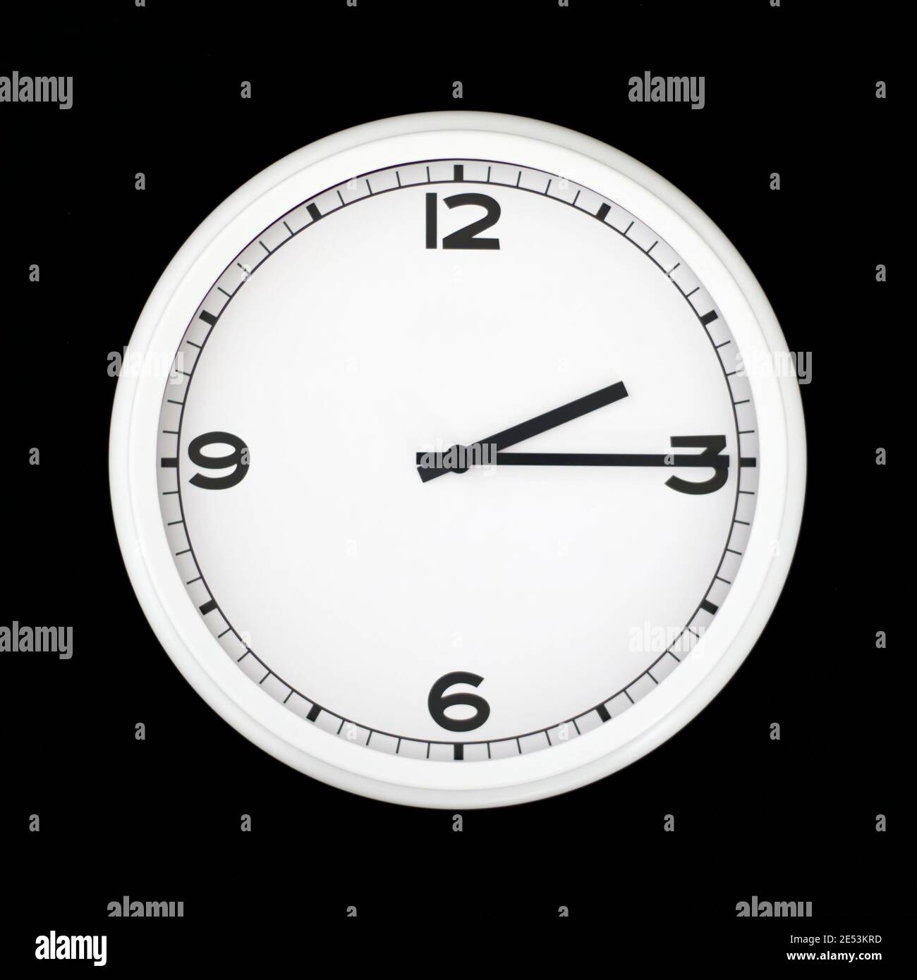 White round analog wall clock isolated on black background, its quarter ...