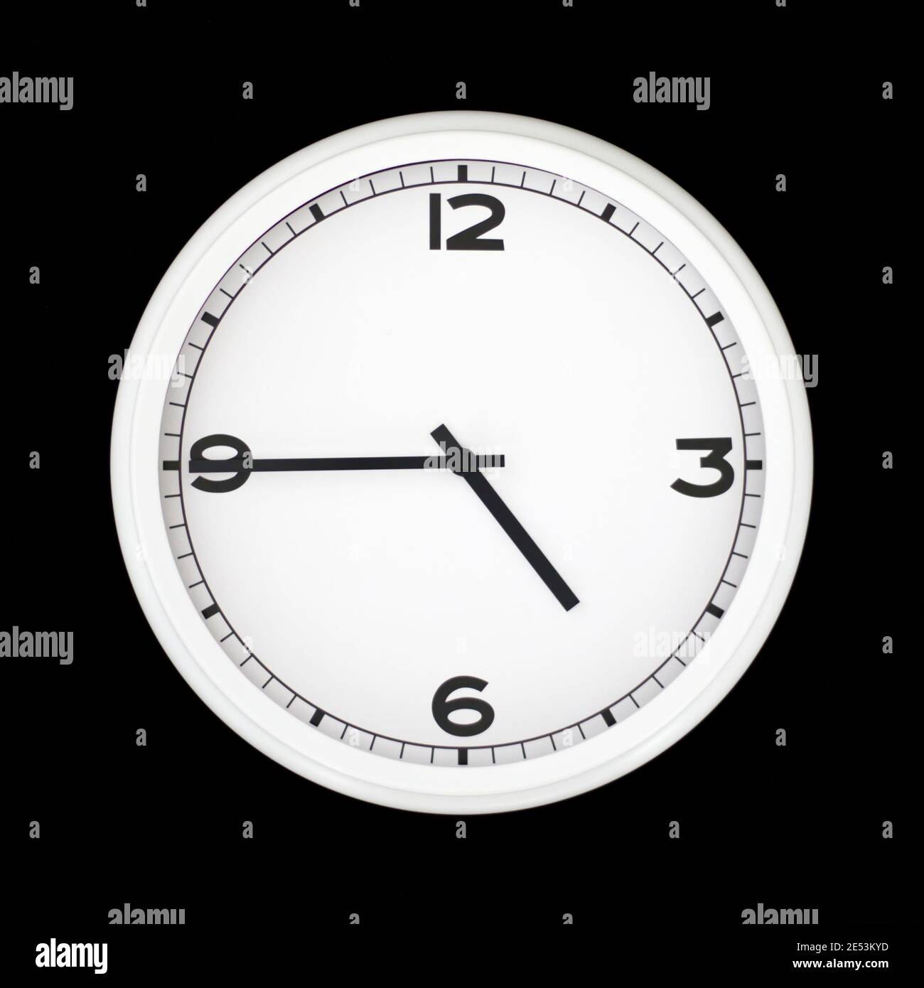 White round analog wall clock isolated on black background, its quarter ...