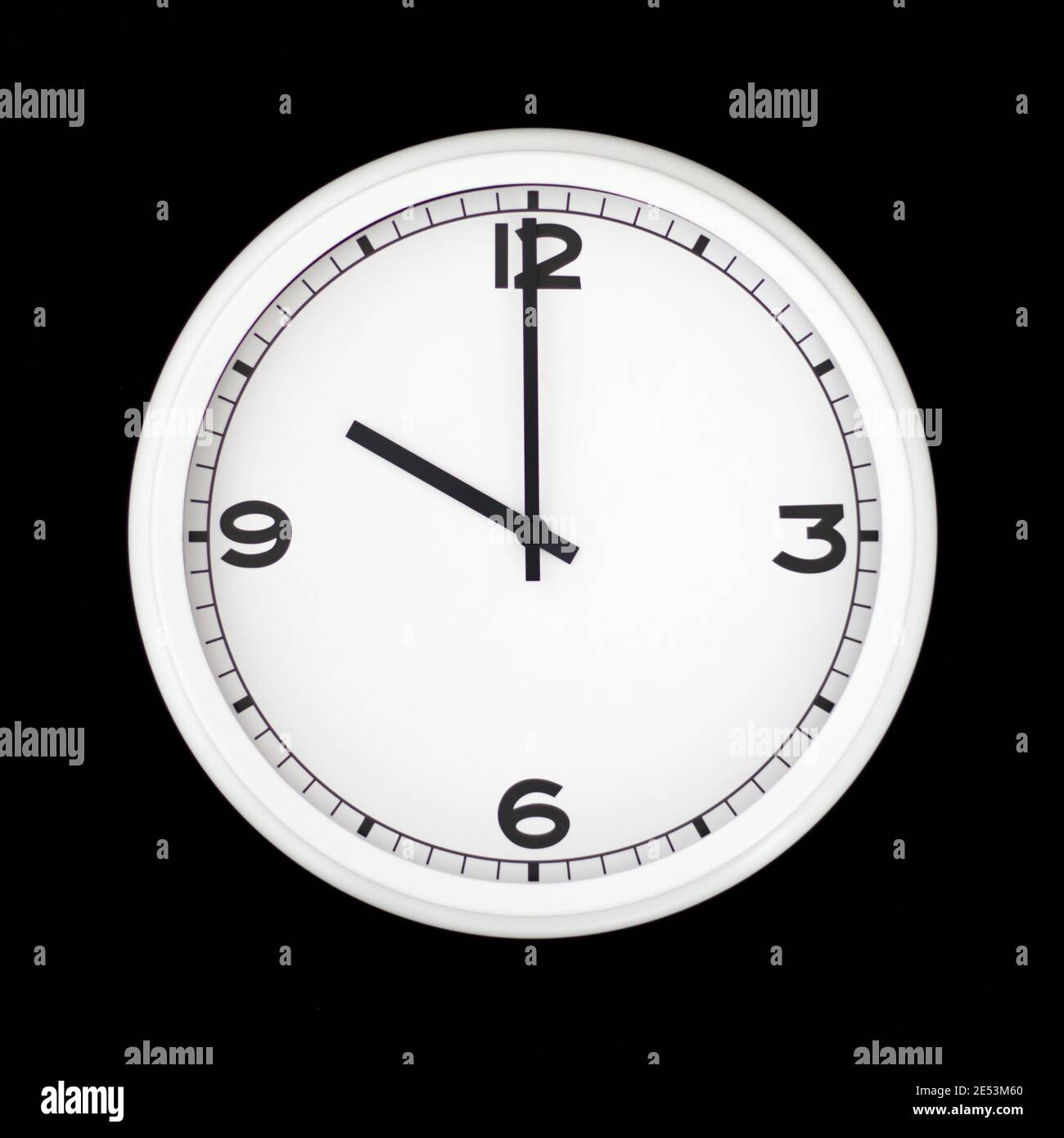 White round analog wall clock isolated on black background, its ten ...