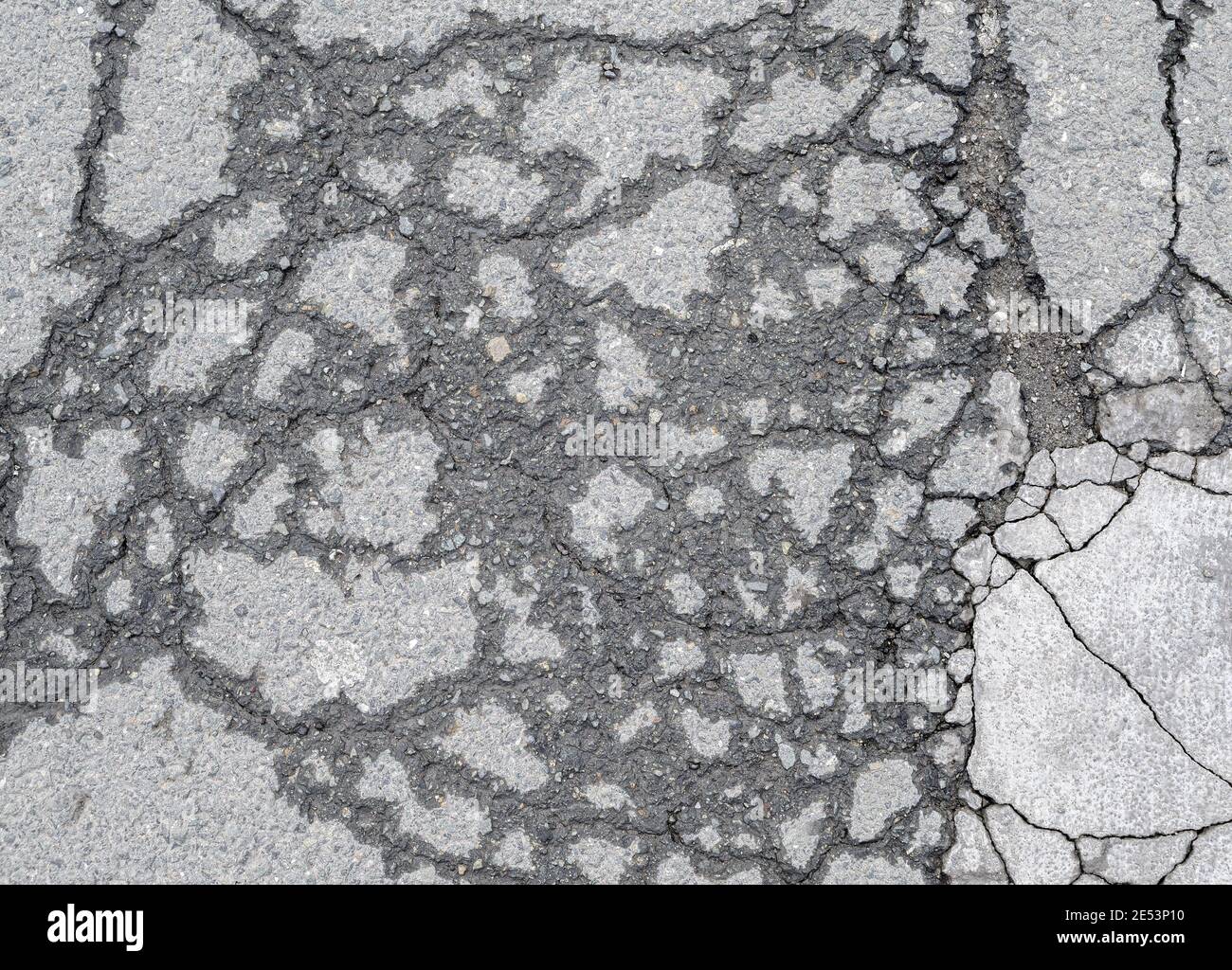 Asphalt road with small rocks and cracks Stock Photo - Alamy