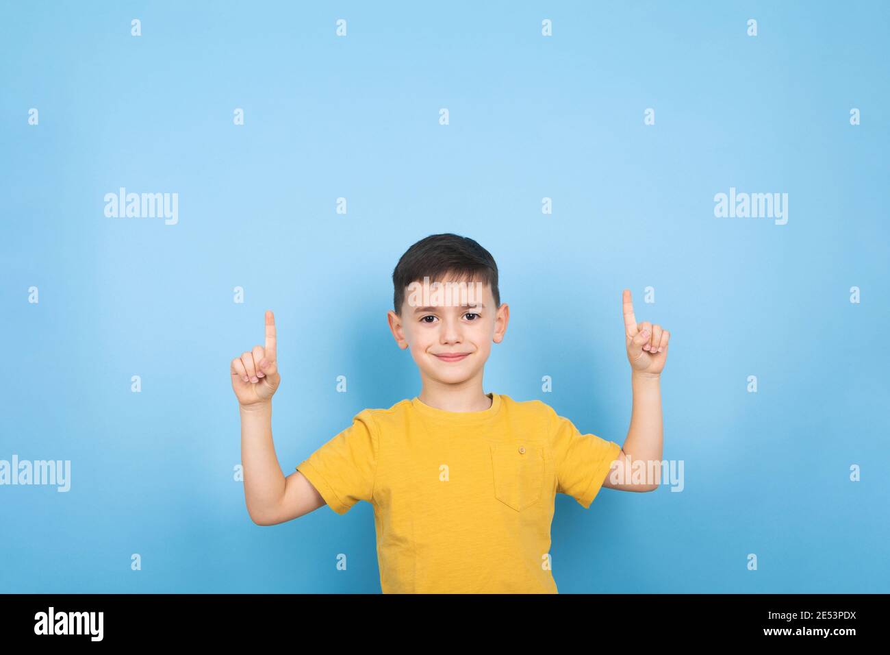 Cheerful little boy looking and pointing up with both hands Stock Photo ...