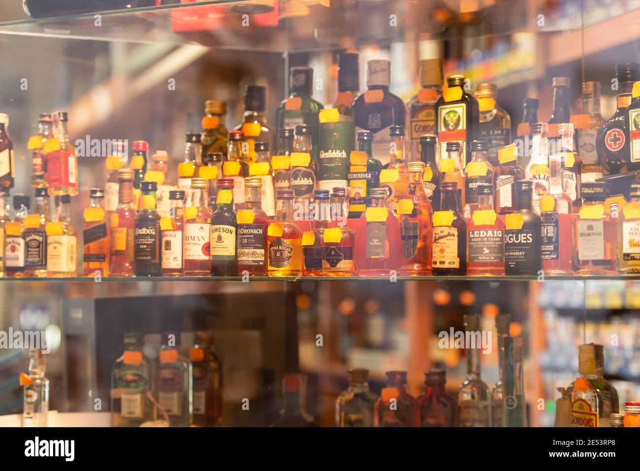 Hundreds of small bottles on display behind glass Stock Photo - Alamy