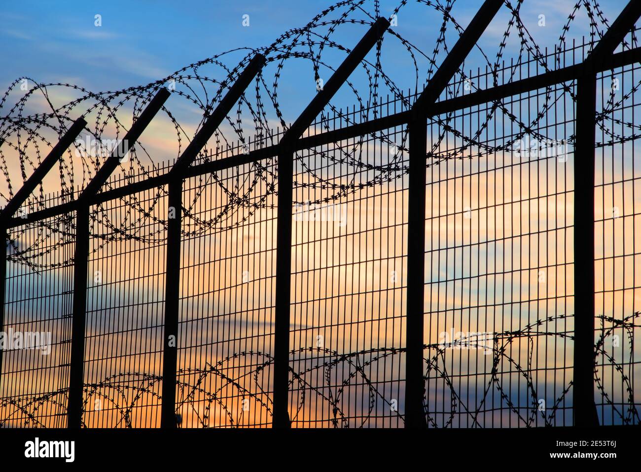 prison barbed wire, at sunset, depression Stock Photo - Alamy