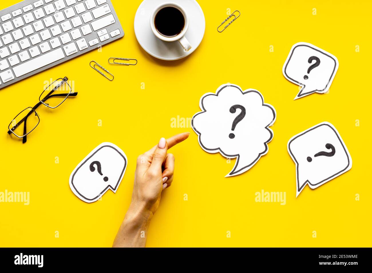 Question marks on office dest - FAQ concept. Top view Stock Photo - Alamy