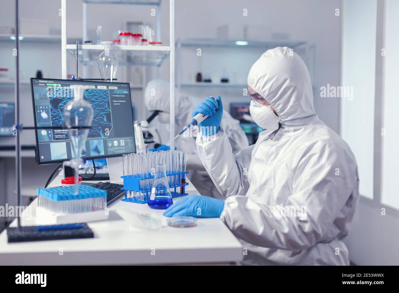 Healthcare scientist taking sample from test tube using automatic ...