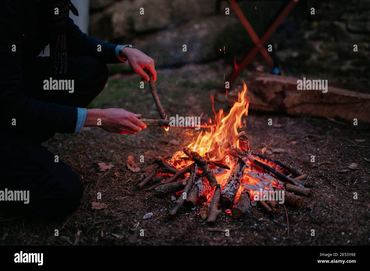 Man Turning on a fire in rural scene Stock Photo - Alamy
