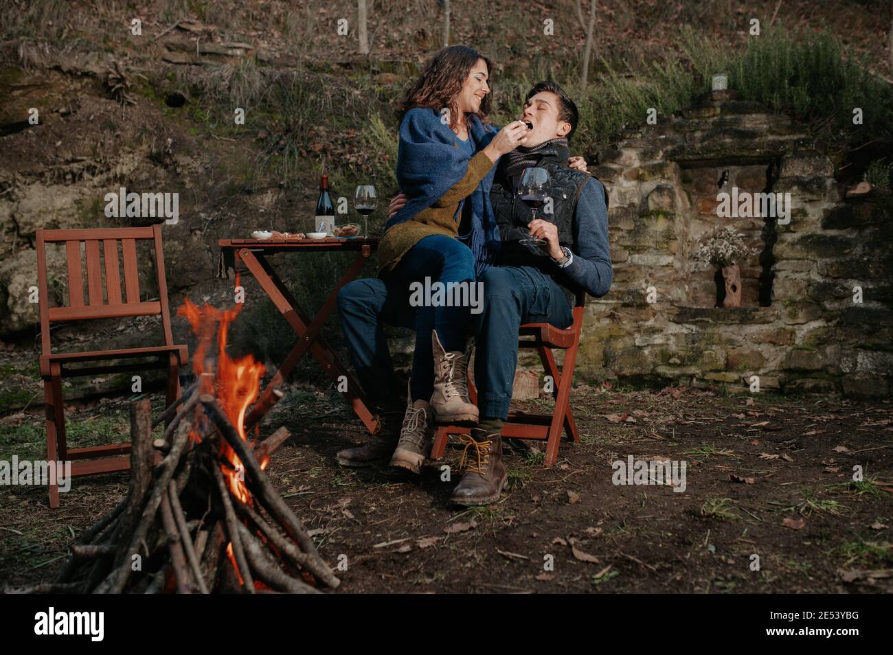 Romantic couple having a picnic with bonfire Stock Photo - Alamy