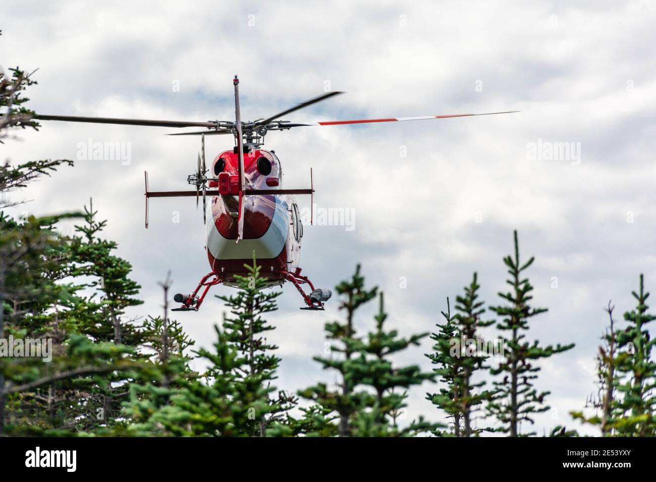 Selective focus closeup of a red and white helicopter landing behind ...