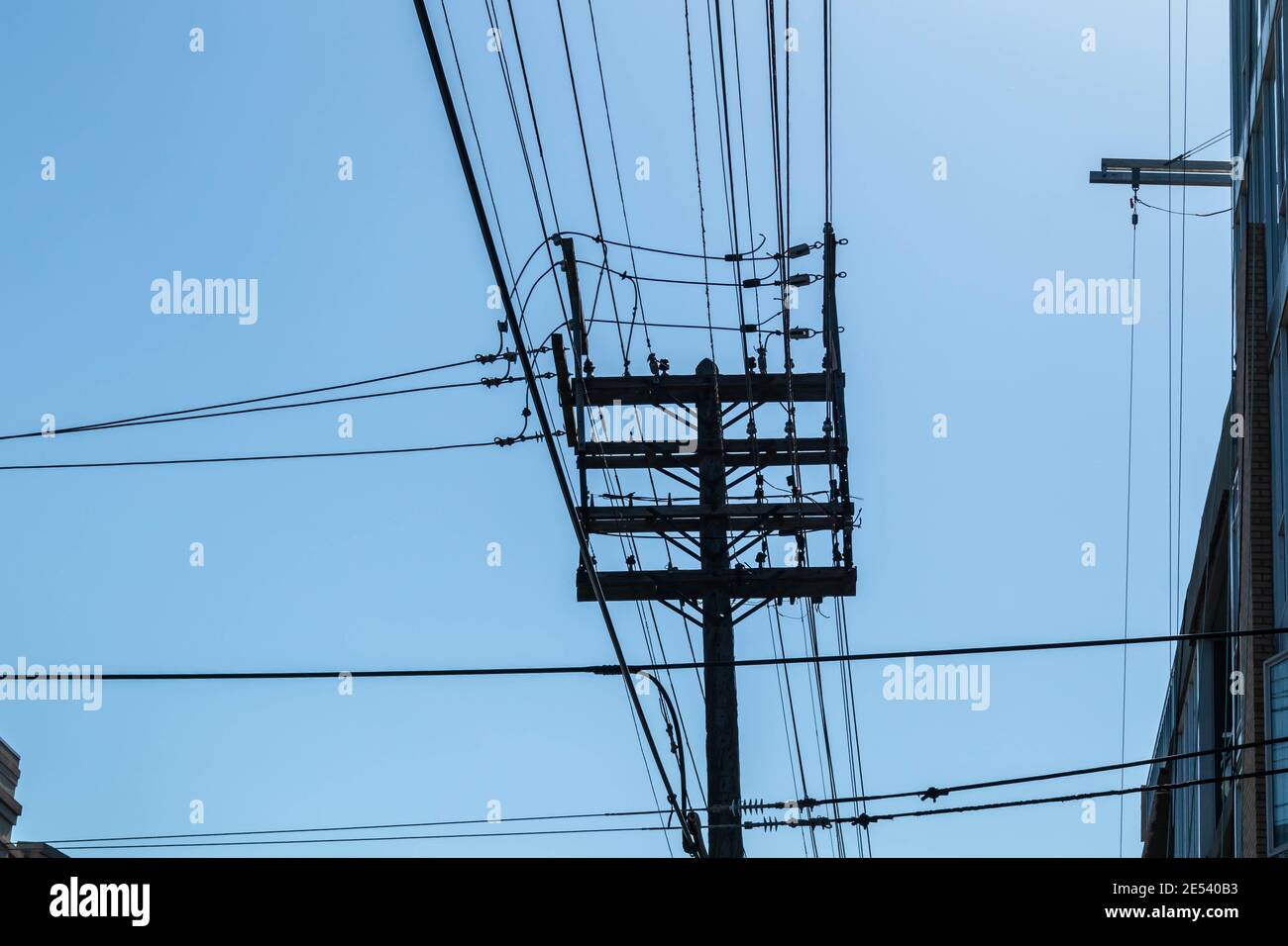 Low angle shot of the overhead wires with clear blue sky behind Stock ...