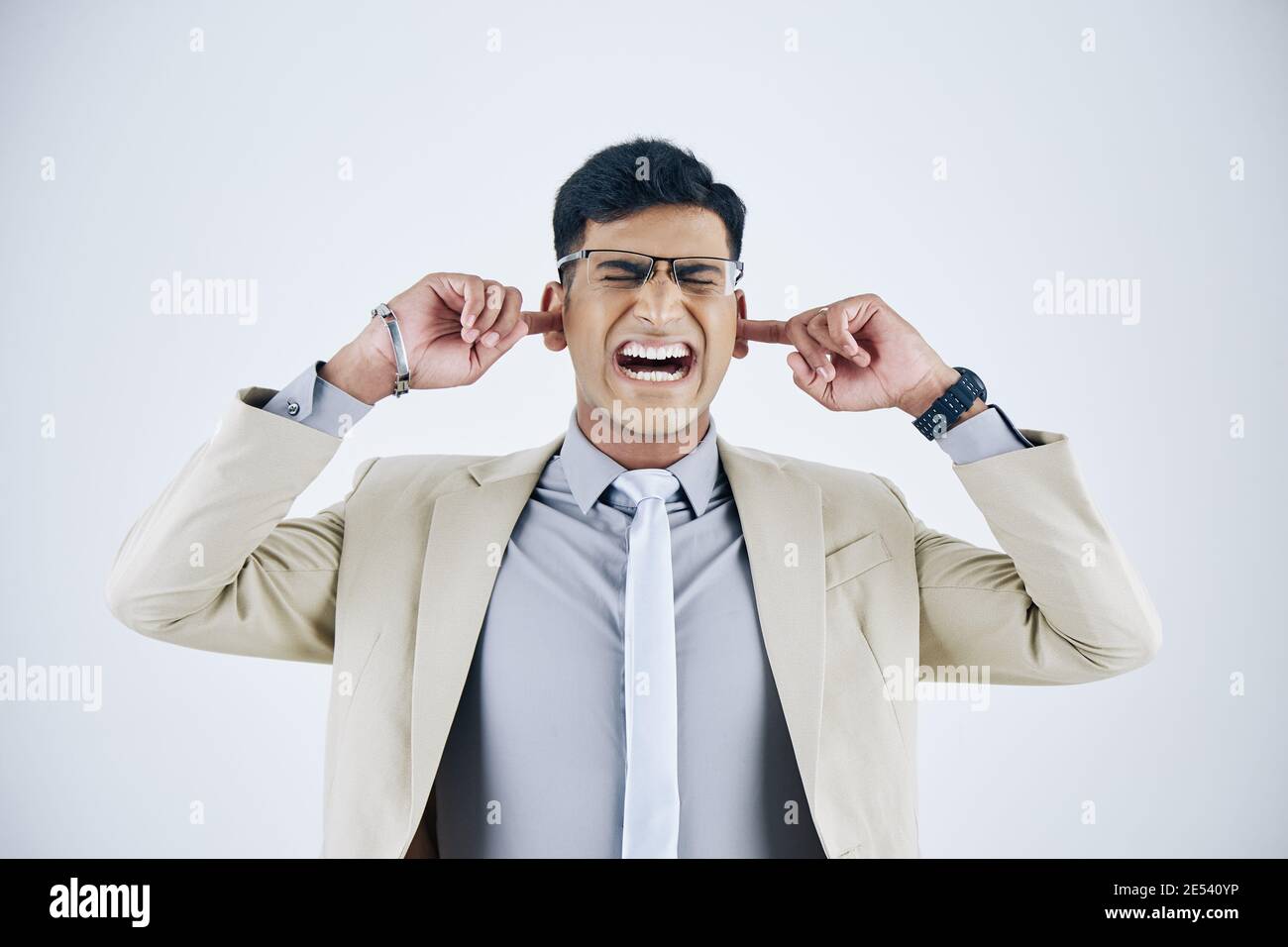 Annoyed irritated and stressed out young Indian businessman plugging ...