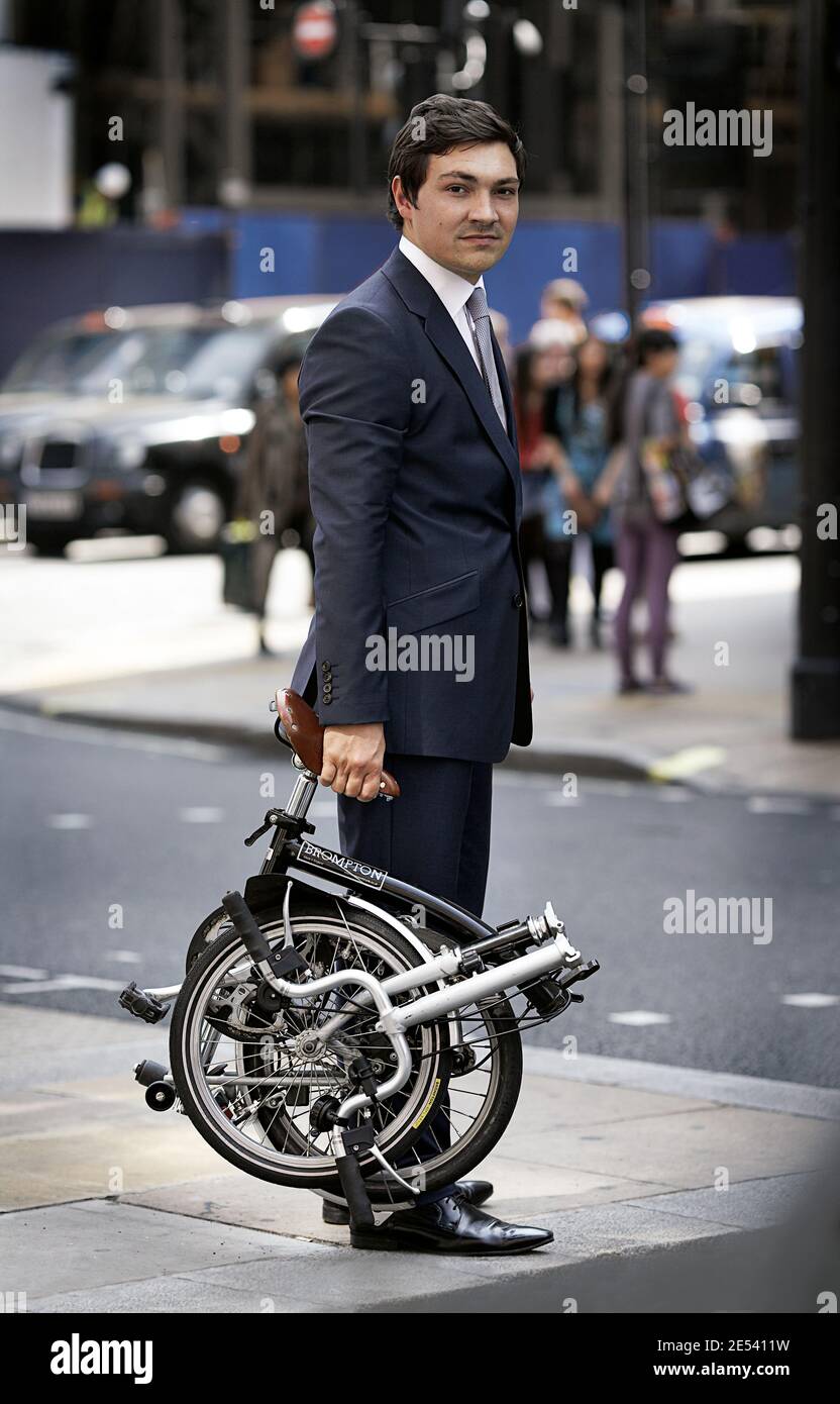 Mid adult businessman carrying folding bicycle - Executive with fold up ...