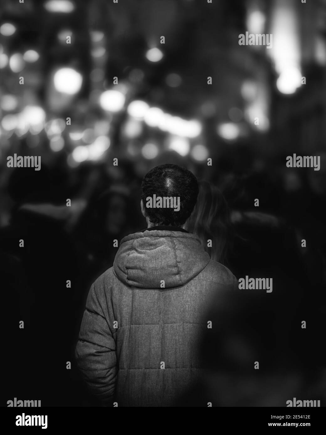 Vertical grayscale shot of a male standing in the crowd Stock Photo - Alamy