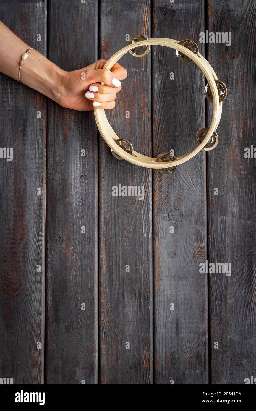 Wooden tambourine in hand. Percussion musical instrument, top view ...