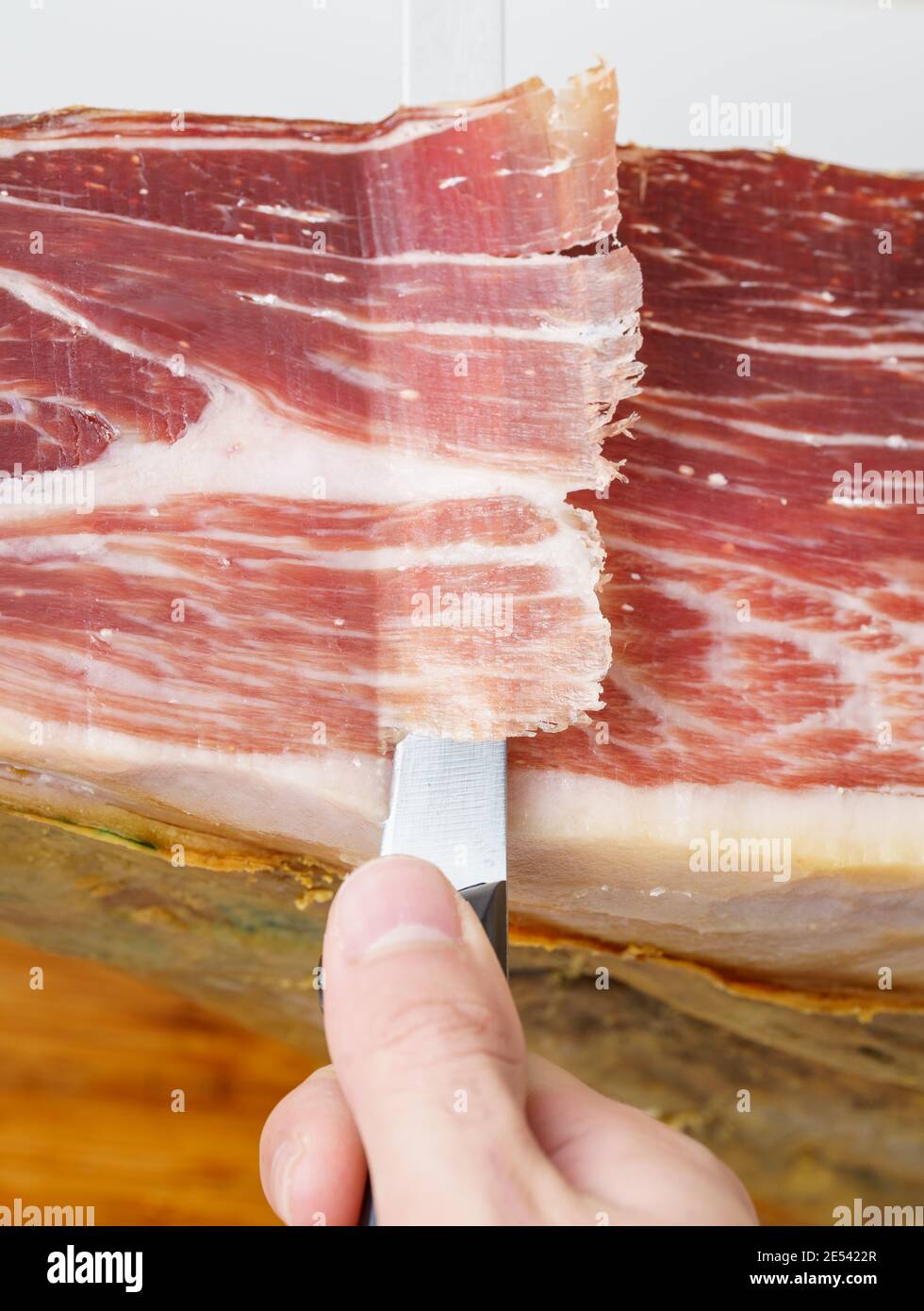 Cut of acorn-fed Iberian ham on metal and wood ham holder, typical ...