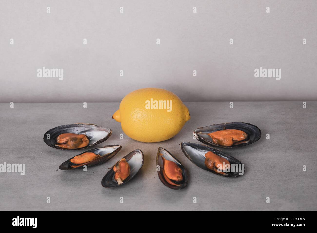 Seafood with lemon. The delicious, cooked mussels on a grey stone ...