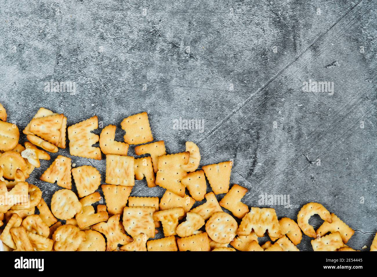Scattered alphabet crackers on a marble background Stock Photo - Alamy
