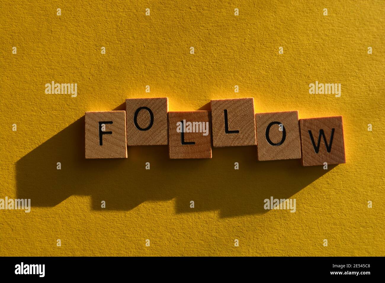 Follow, word in wooden alphabet letters isolated on bright yellow ...