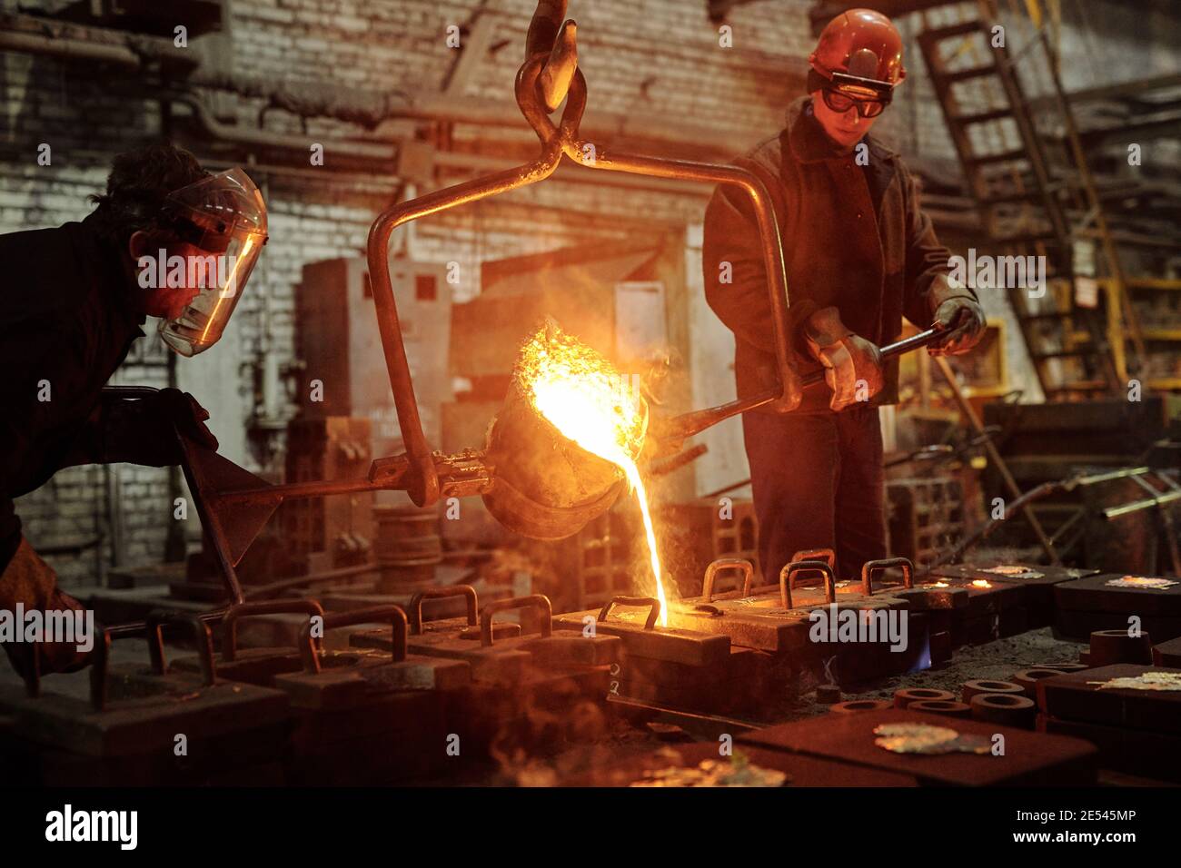The welder works in the factory shop two steel workers melting metal ...