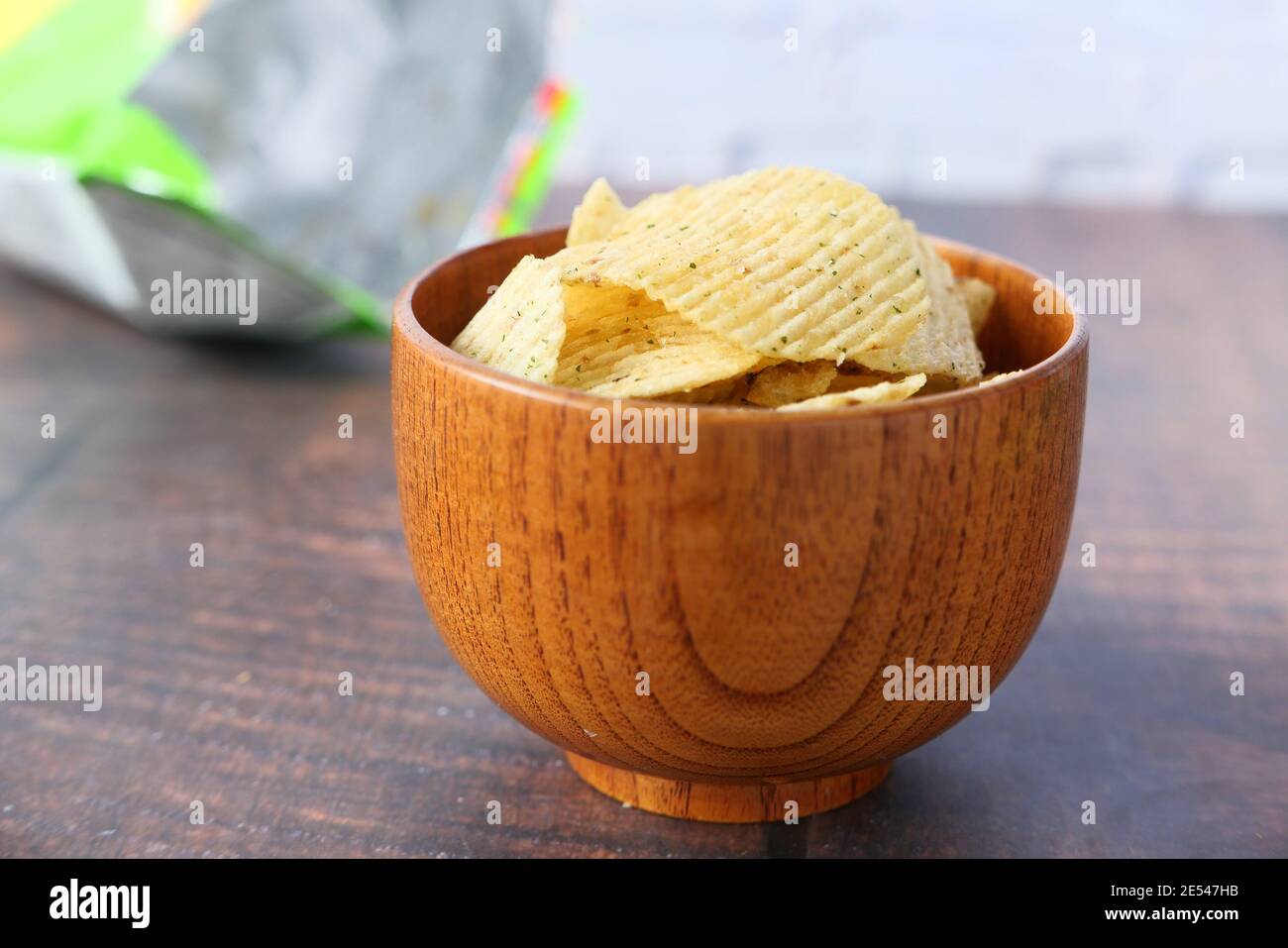Bowl with tasty potato chips on wooden background Stock Photo - Alamy