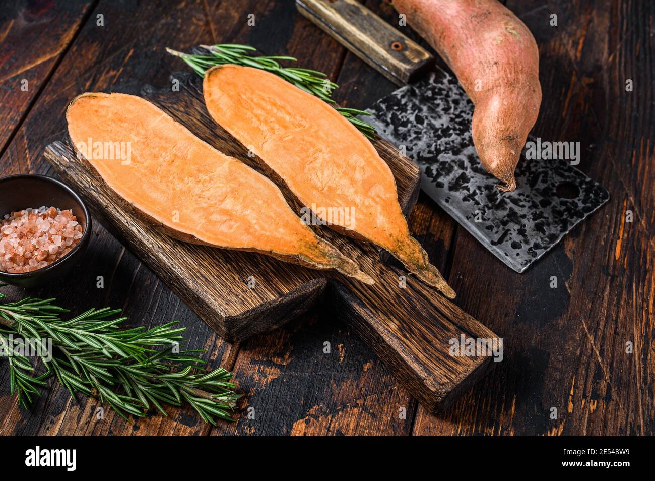 Raw cut Sweet potato on Wooden cutting board. Dark wooden background ...
