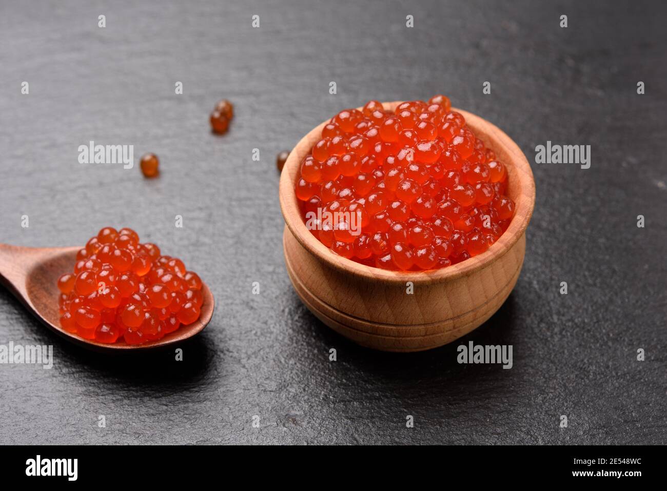 fresh grainy red chum salmon caviar in a wooden spoon, delicious and ...